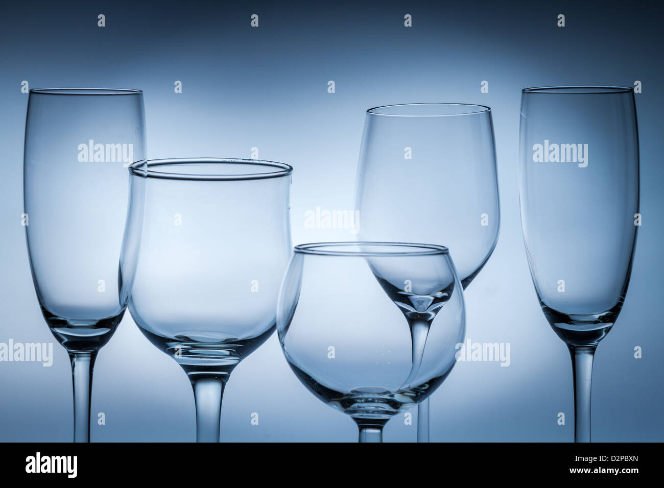 Closeup of empty glasses on a blue background Stock Photo - Alamy
