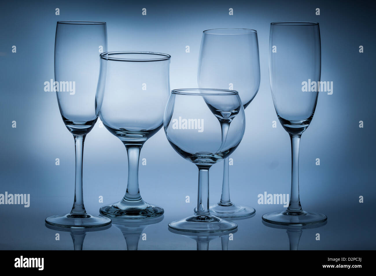 Different types of empty glasses on a blue background Stock Photo - Alamy