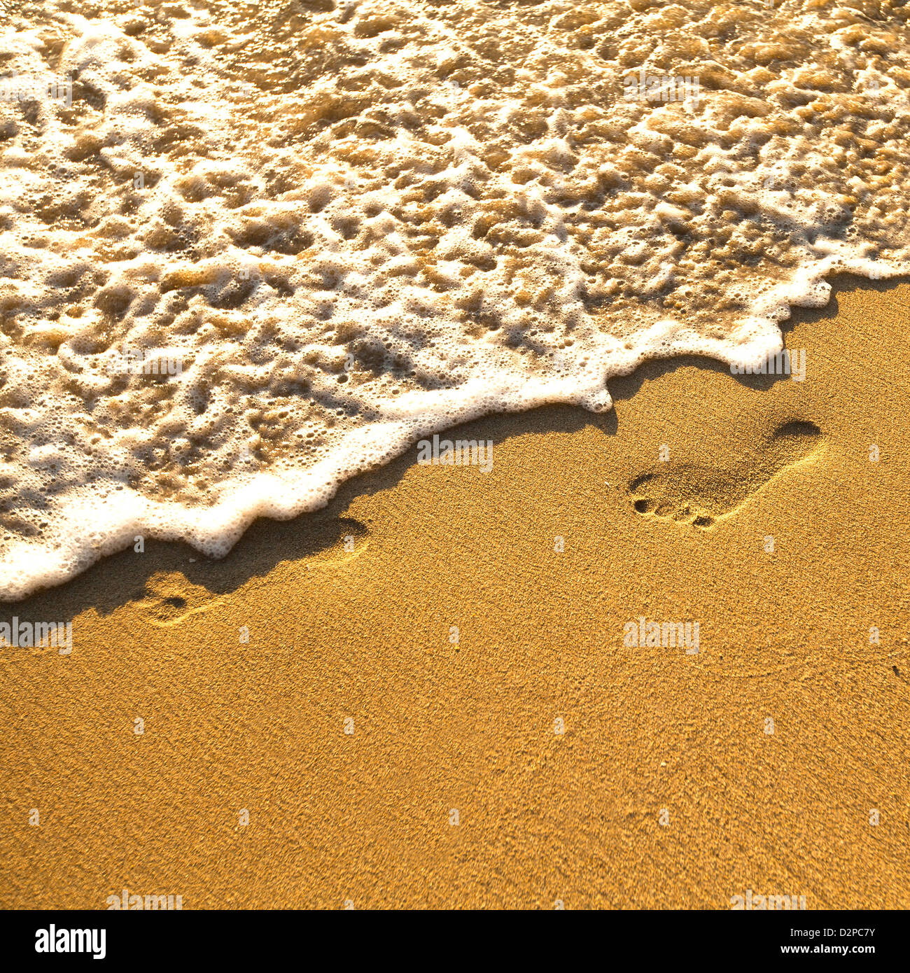 Footprint on sand with foam Stock Photo - Alamy