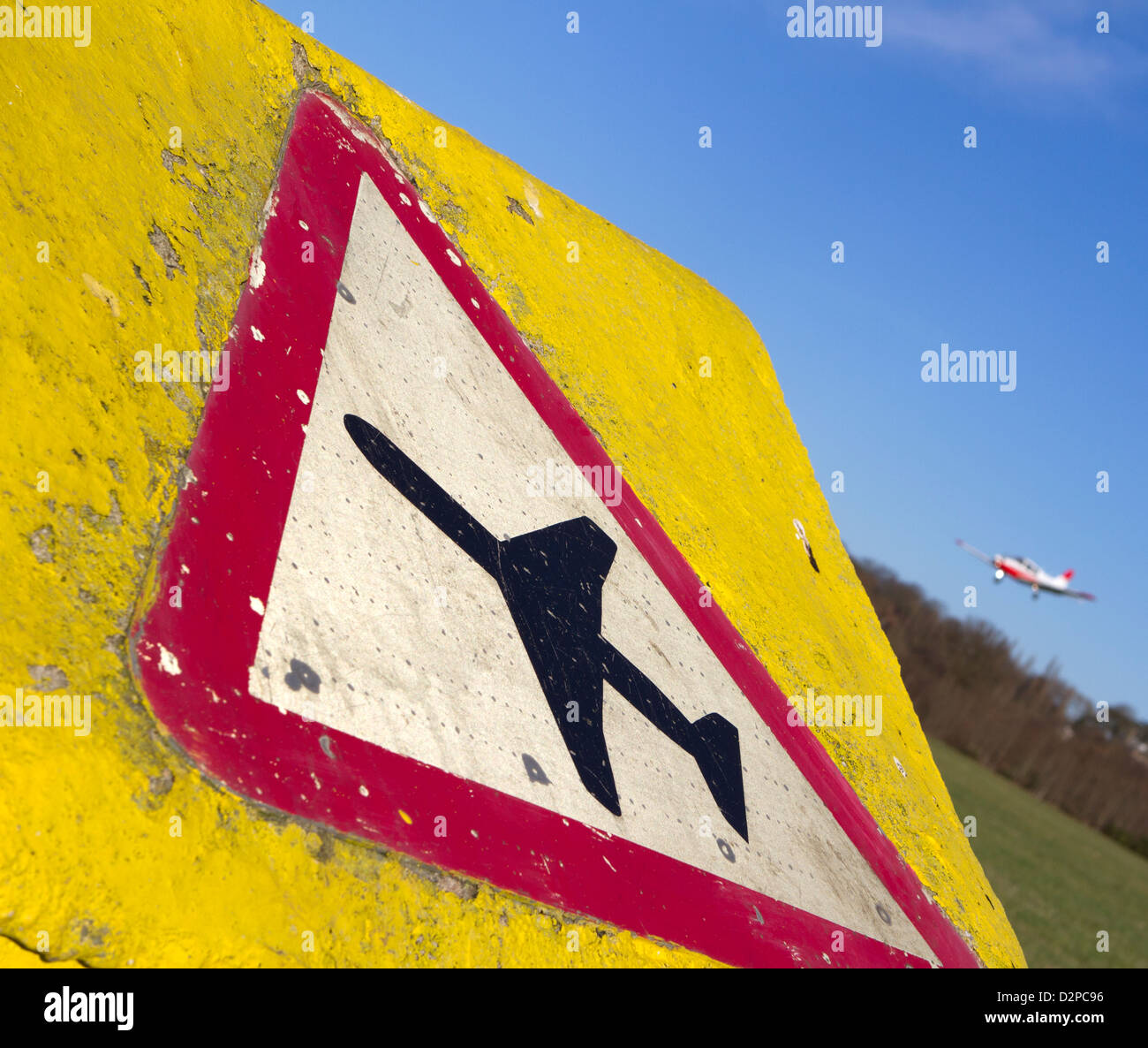 Small aircraft comes in to land by a low flying plane sign Stock Photo ...
