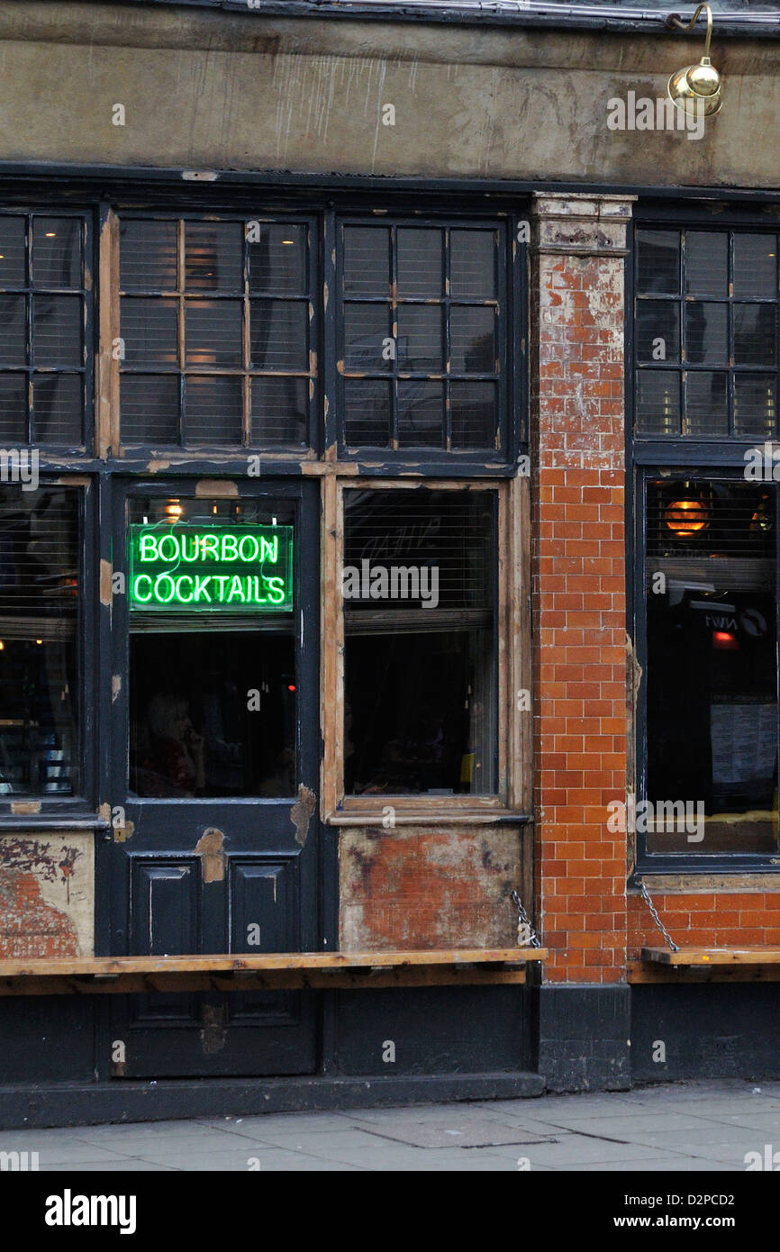 Green neon sign advertising Bourbon Cocktails in the window of a pub ...