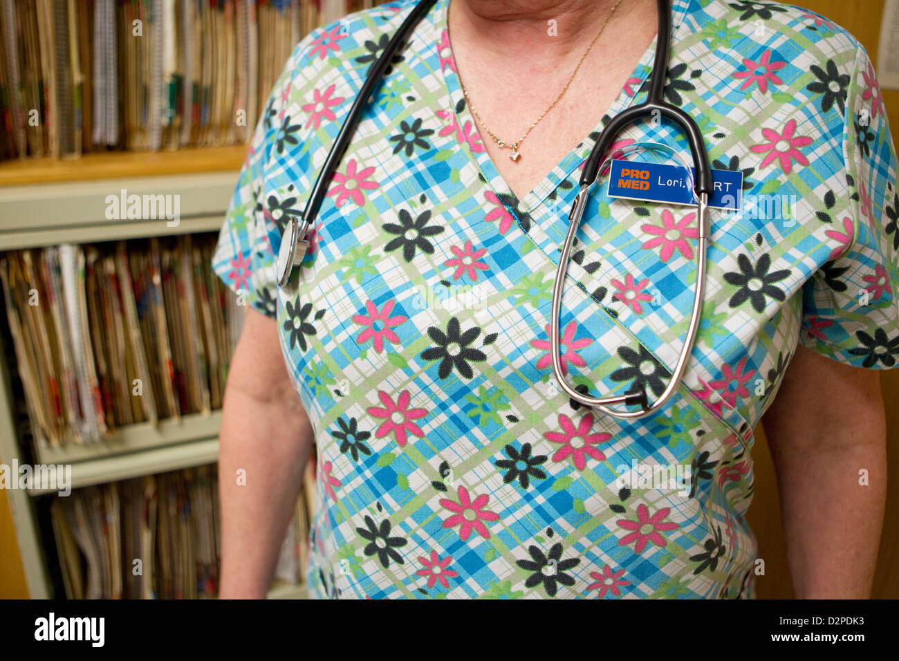 Female medical technician wearing scrubs and stethoscope poses in front ...