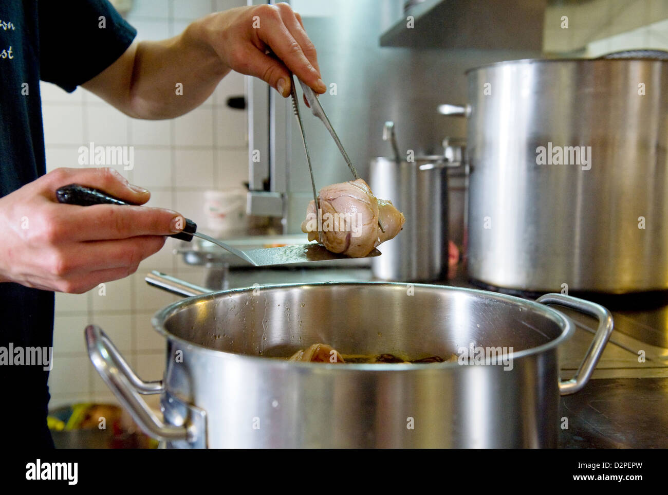 Berlin, Germany, chef Marco Mueller during cooking of pork knuckle ...