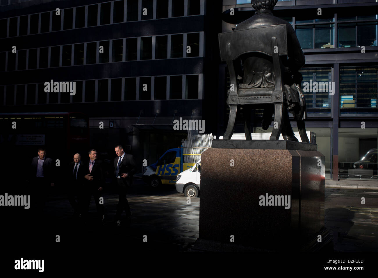 Businessmen walk past the statue of George Peabody in the heart of the ...