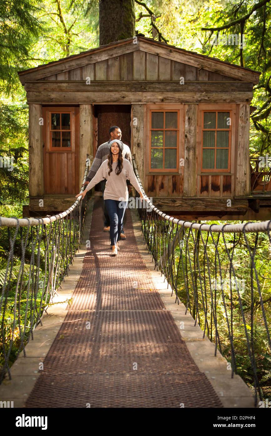 Couple on walkway of remote tree house Stock Photo - Alamy