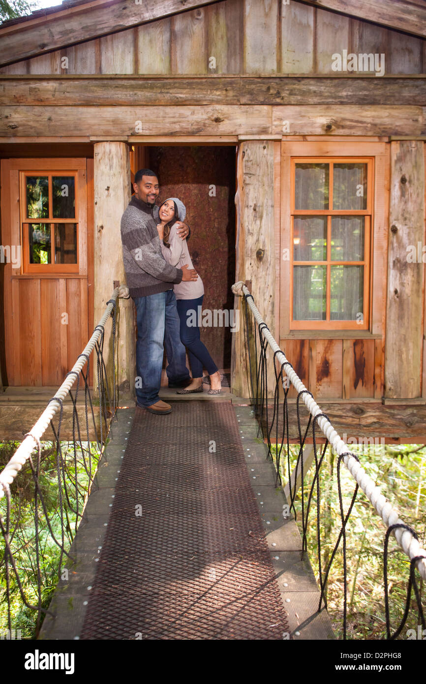 Couple on walkway of remote tree house Stock Photo - Alamy