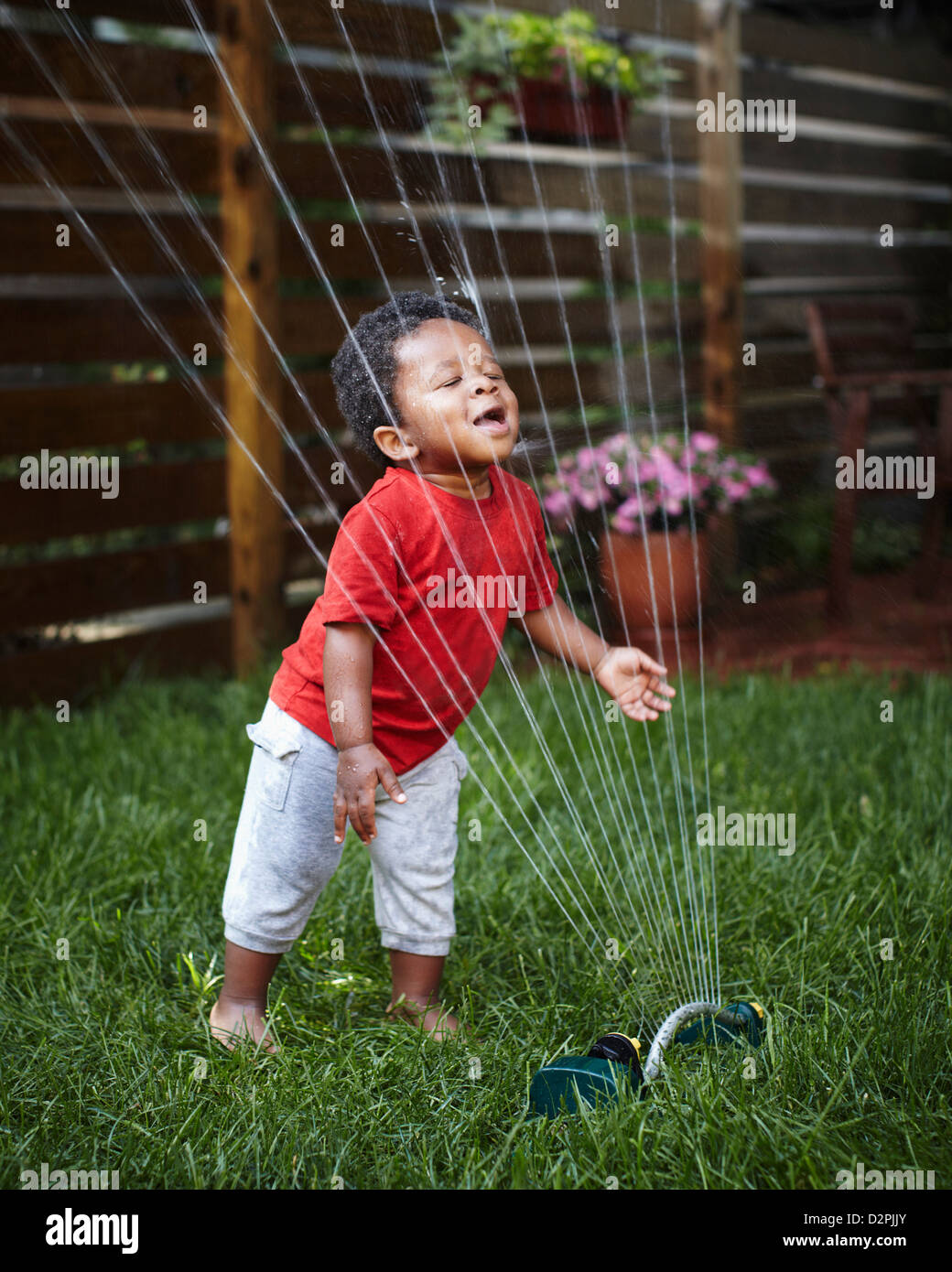 African American baby playing in sprinkler Stock Photo - Alamy