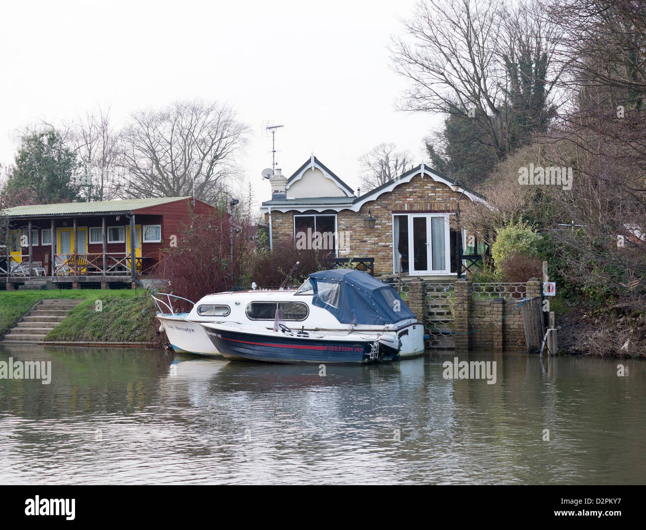 Small boats moored beside a riverside small house at Shepperton ...