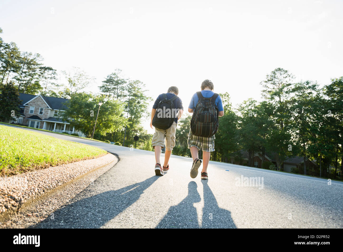 Caucasian boys walking in road Stock Photo - Alamy