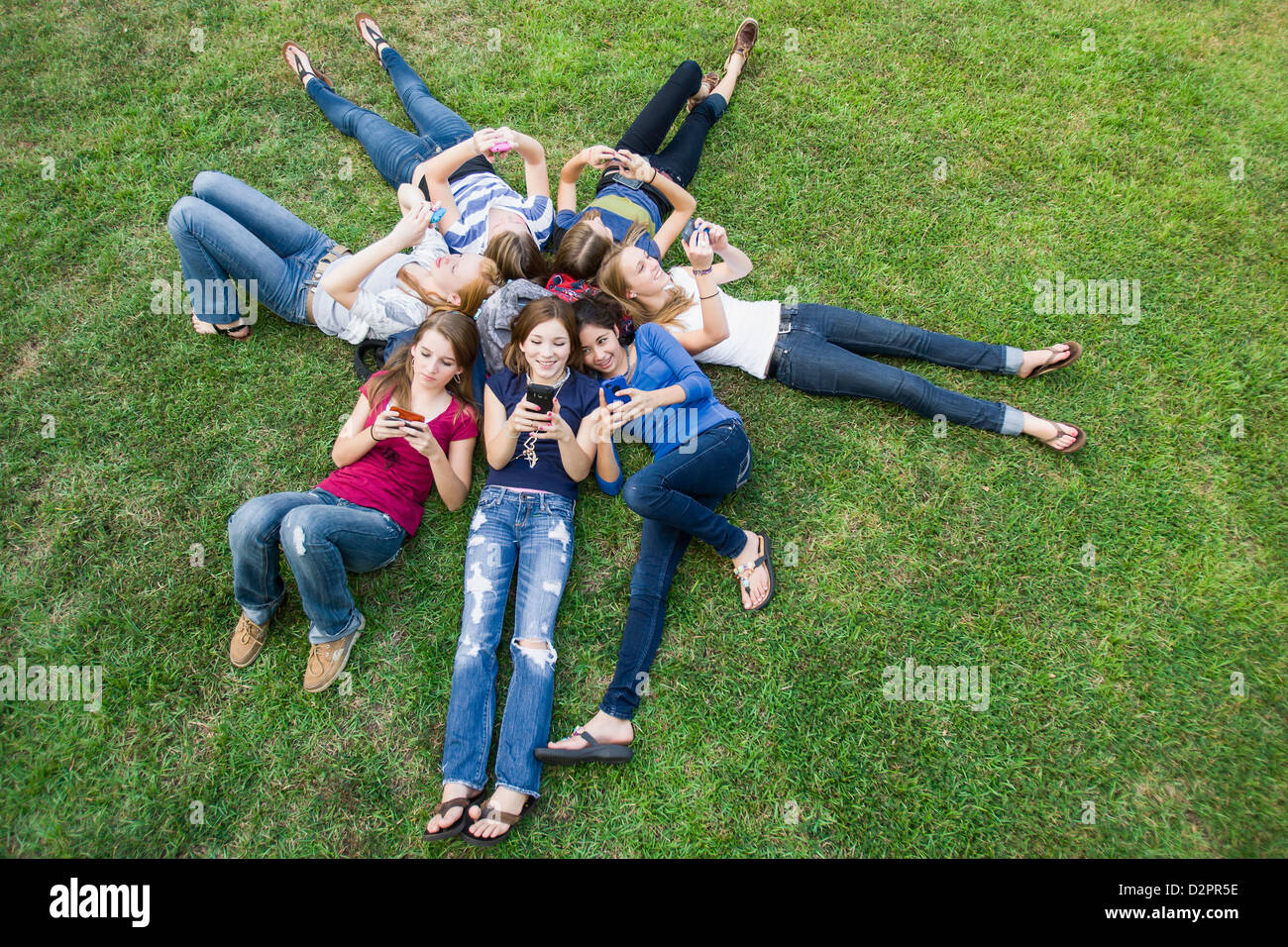 Friends hanging out together on grass Stock Photo - Alamy