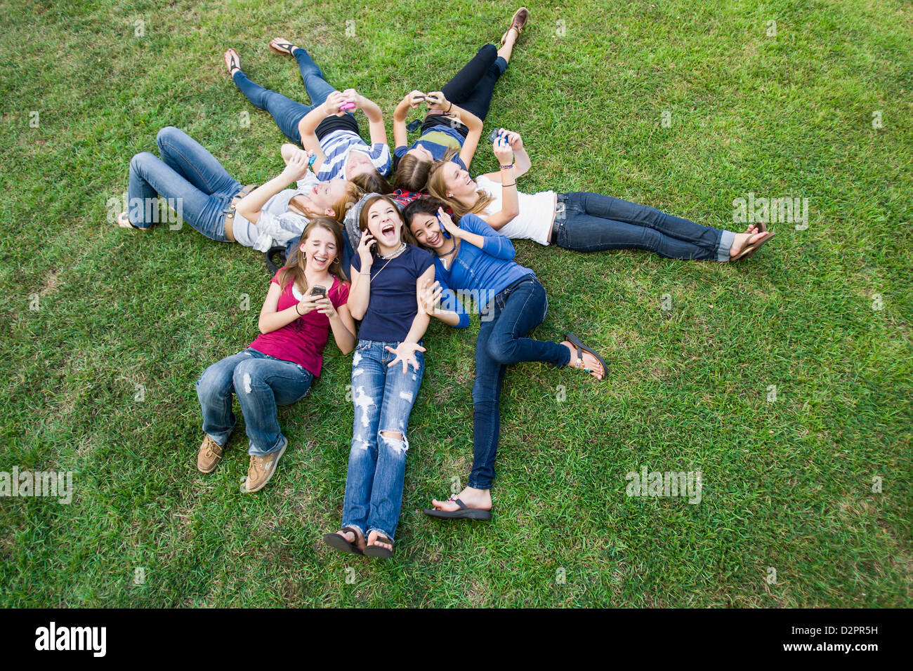 Friends hanging out together on grass Stock Photo - Alamy