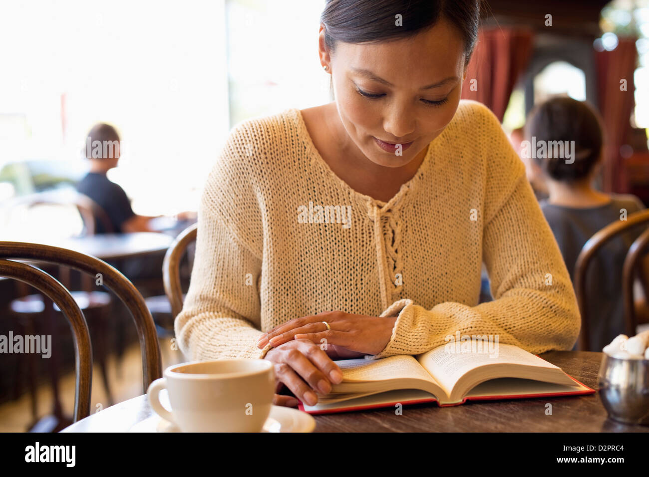 Filipino woman reading book in cafe Stock Photo - Alamy