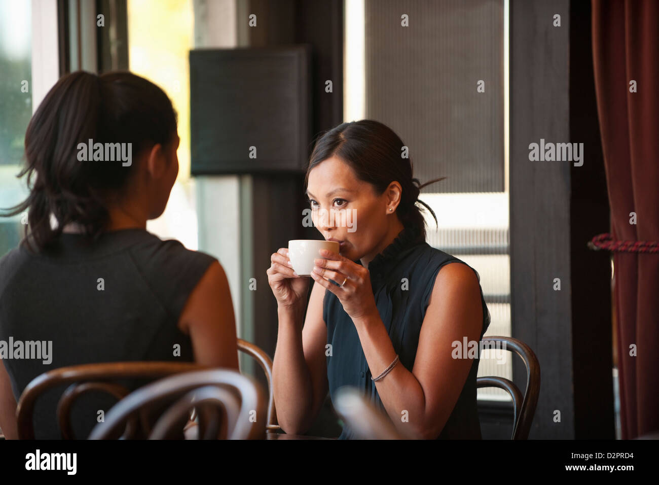 Asian friends sitting together in cafe Stock Photo - Alamy