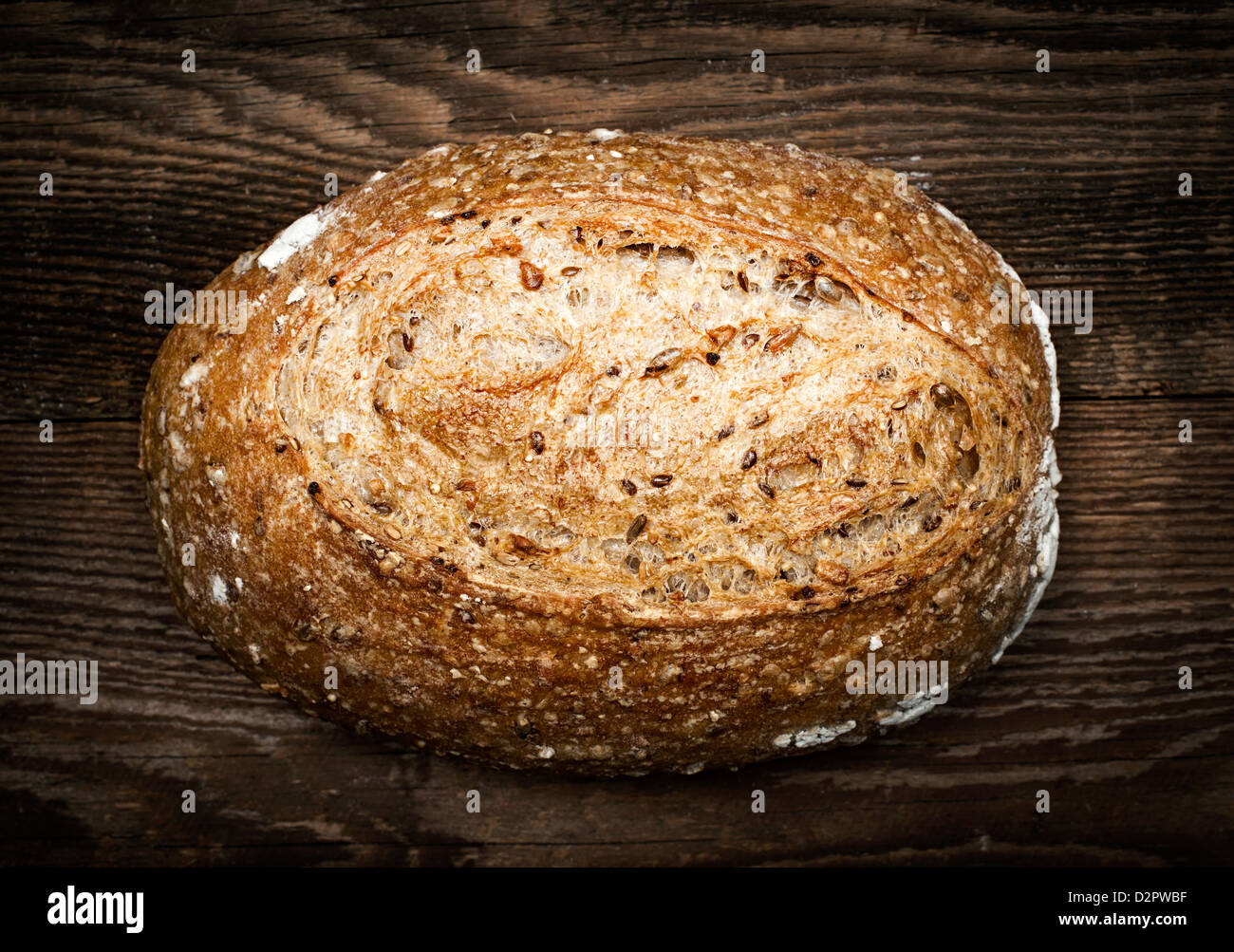 Artisan loaf of freshly baked multigrain bread on wooden background ...