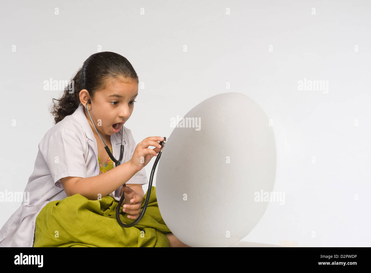 Girl examining a egg with a stethoscope Stock Photo - Alamy
