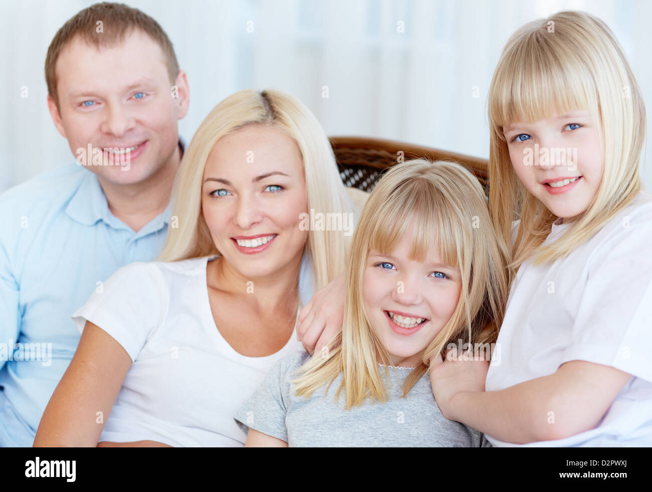 Portrait of happy family with twin daughters smiling at camera Stock ...