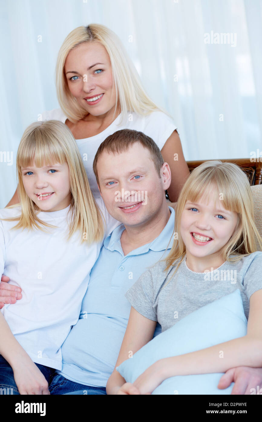 Portrait of happy family with twin daughters smiling at camera Stock ...