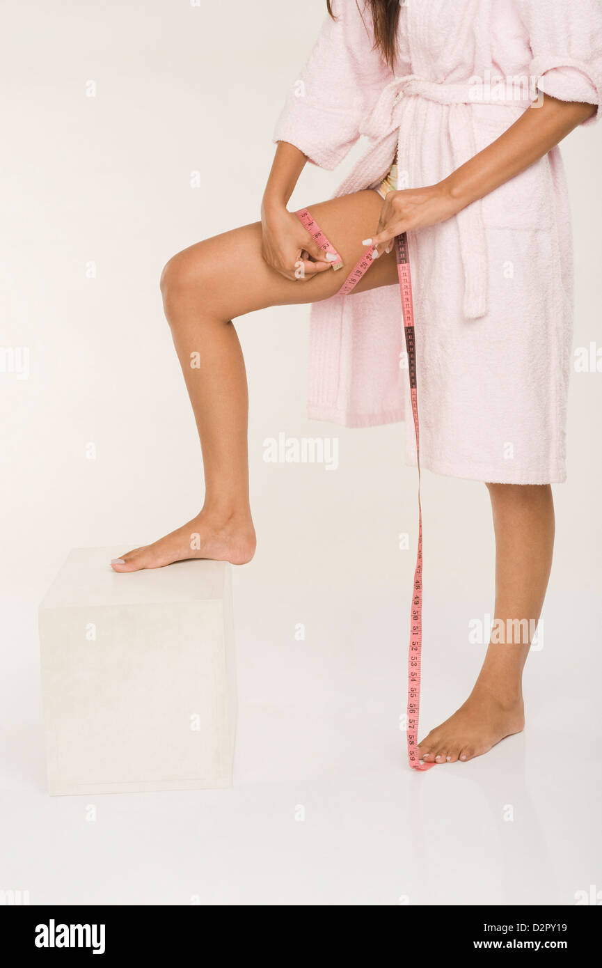 Woman measuring her thigh Stock Photo - Alamy