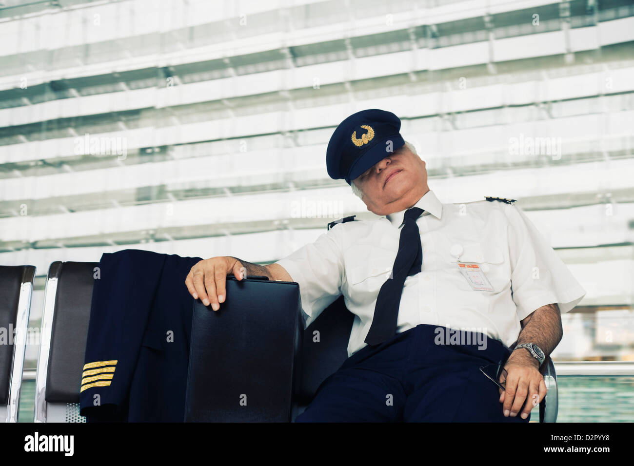 Pilot resting on a bench at an airport Stock Photo - Alamy
