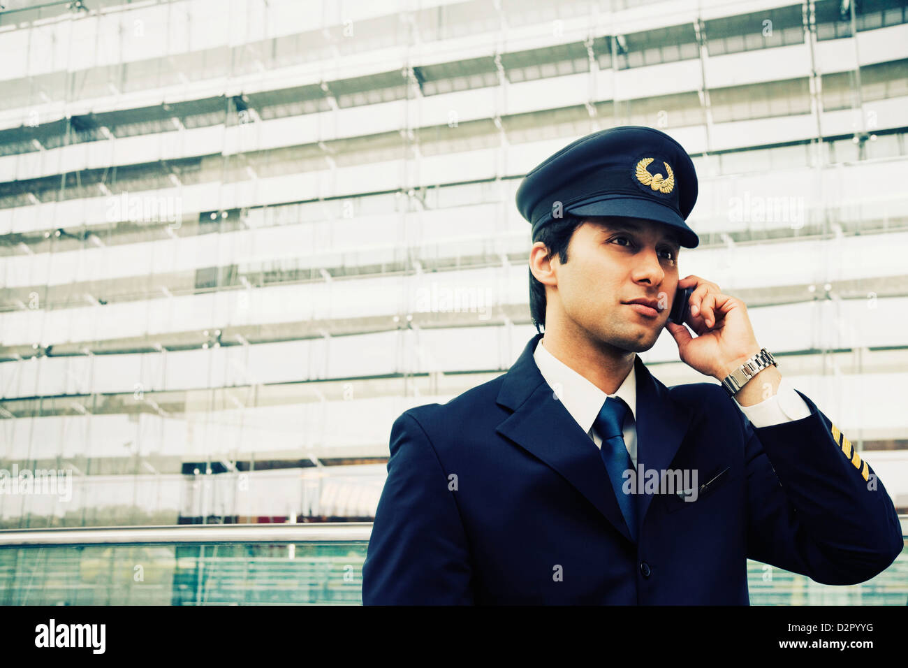 Pilot talking on a mobile phone at an airport Stock Photo - Alamy