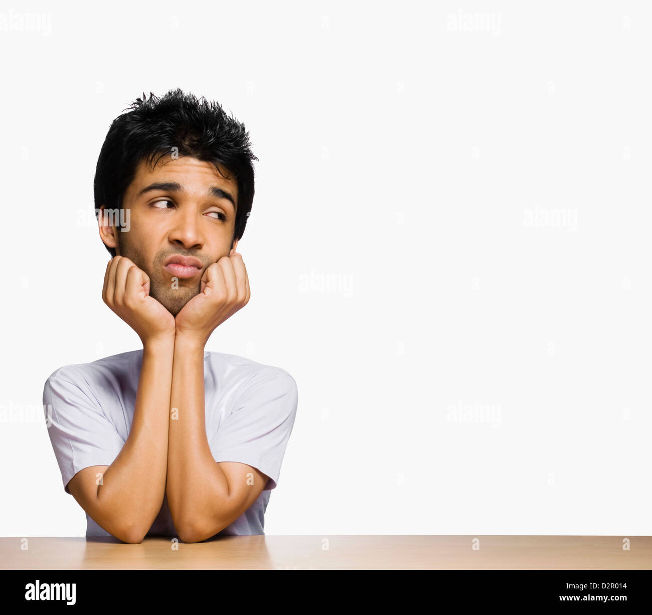 Sad man looking sideways with his hands on chin Stock Photo - Alamy