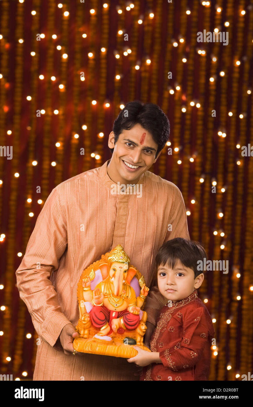 Father and son holding an idol of lord Ganesha Stock Photo - Alamy