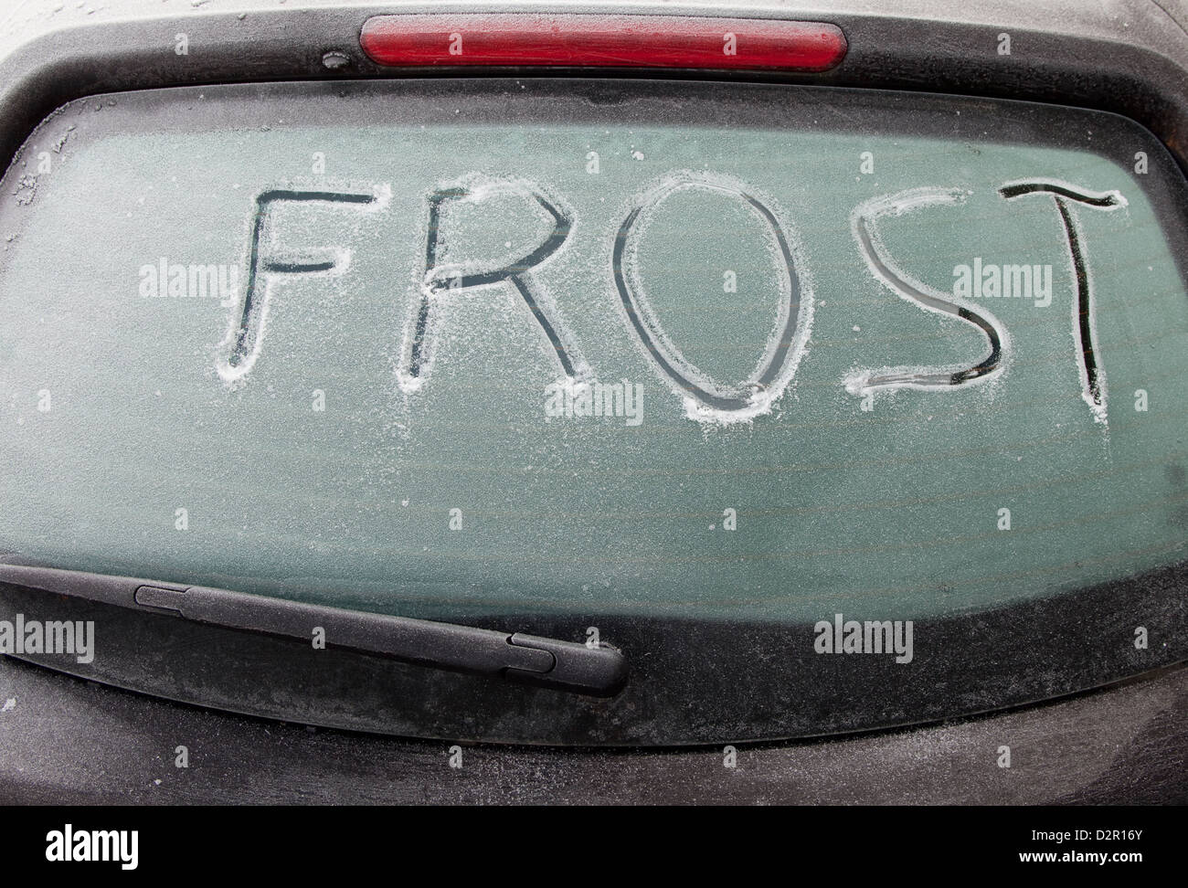 Frost written on the frozen glass of a rear car window Stock Photo - Alamy