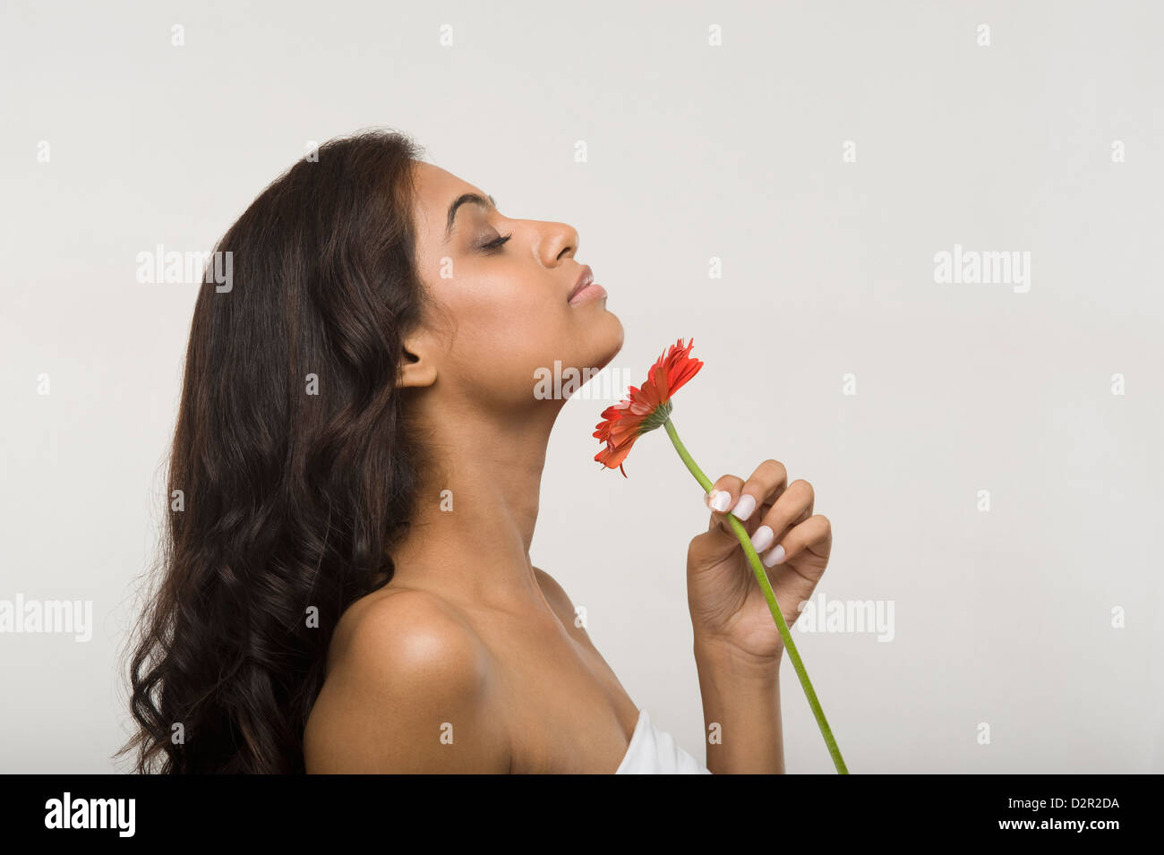 Woman smelling a daisy flower Stock Photo - Alamy
