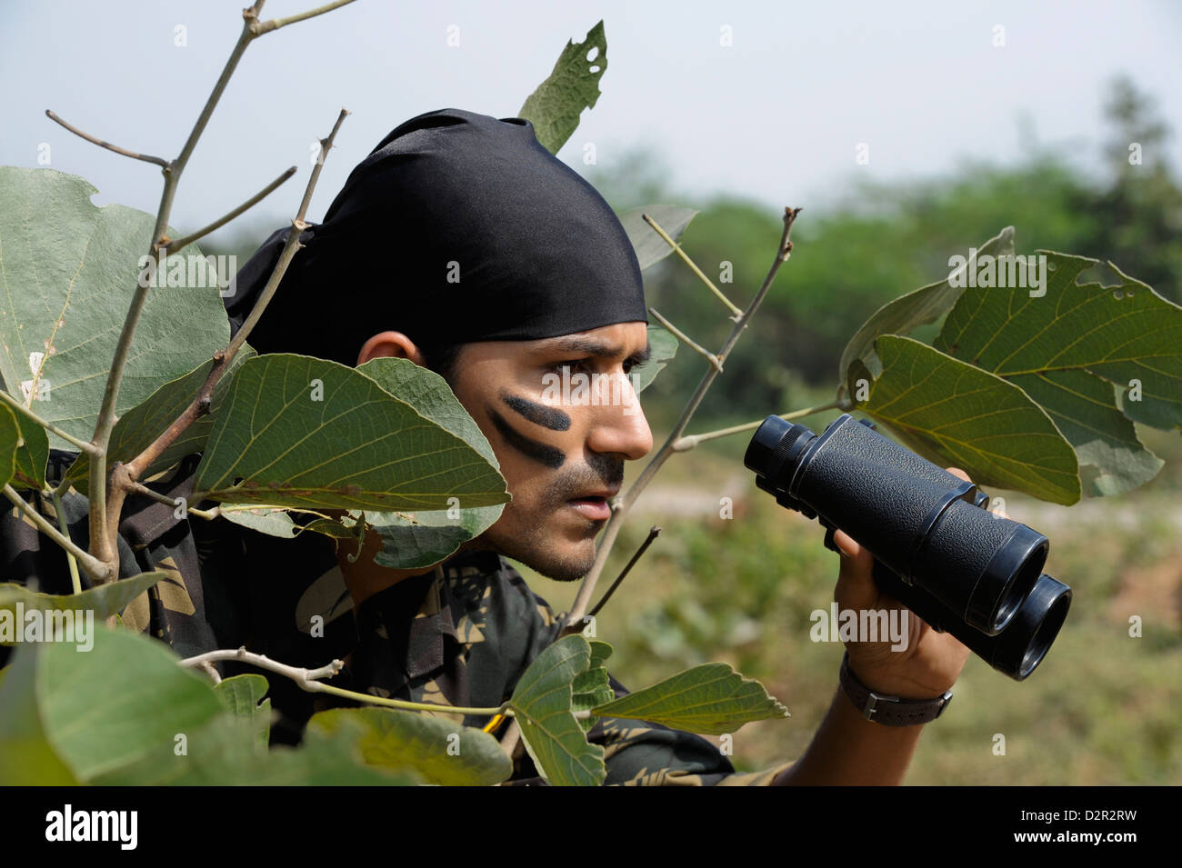 Soldier holding binoculars in a forest Stock Photo - Alamy