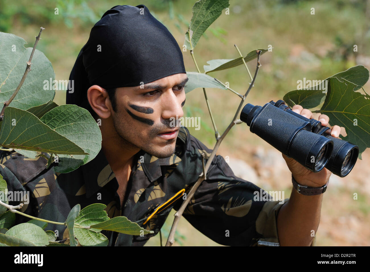 Soldier holding binoculars in a forest Stock Photo - Alamy