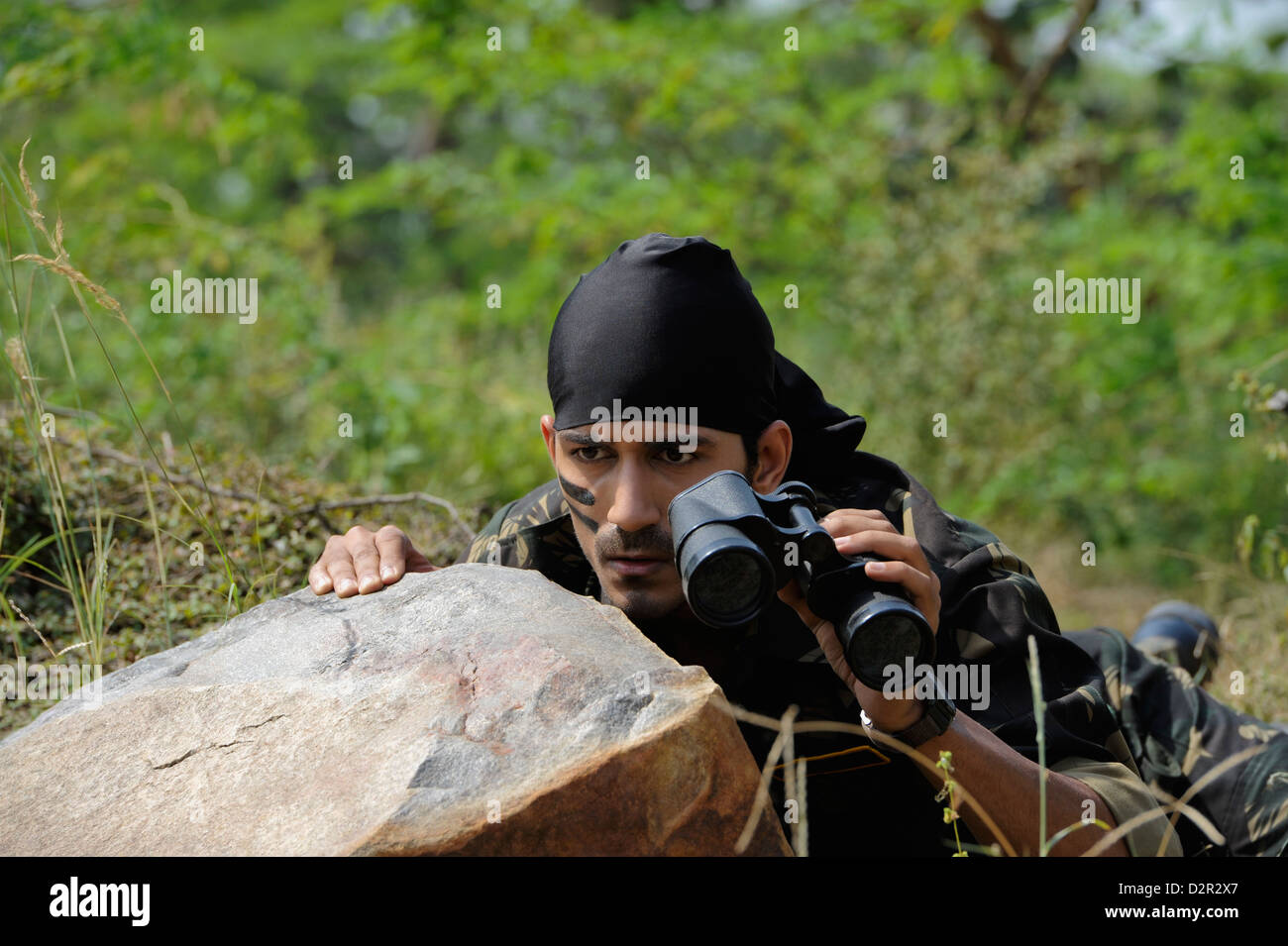 Soldier hiding behind a rock with binoculars Stock Photo - Alamy