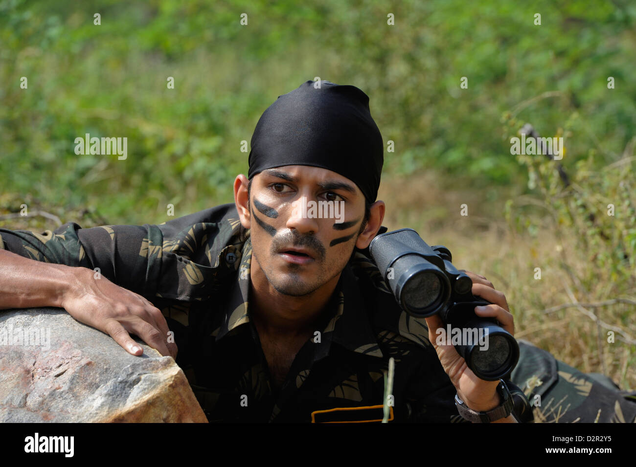 Soldier hiding behind a rock with binoculars Stock Photo - Alamy