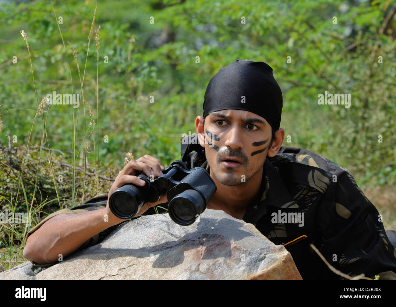 Soldier hiding behind a rock with binoculars Stock Photo - Alamy