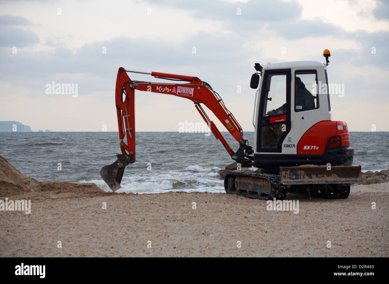 Digger moving sand on beach at Hengistbury Head, Dorset in January ...