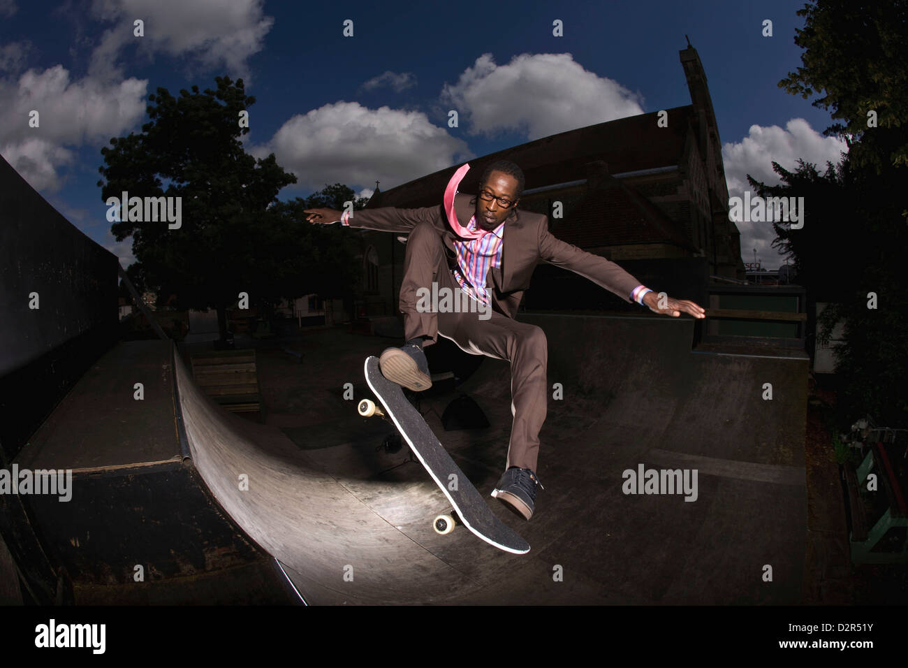Skateboarder in suit on ramp, mid air action stunt Stock Photo - Alamy