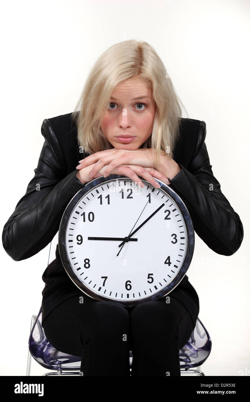 Woman leaning on wall clock Stock Photo - Alamy