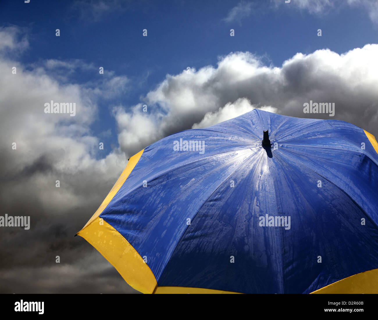 Blue - yellow beach umbrella on a background clouds Stock Photo - Alamy