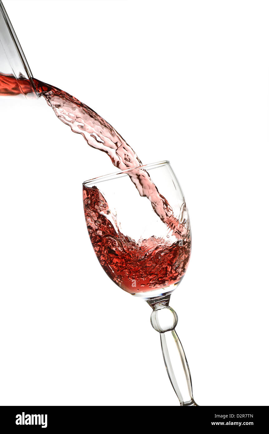 Pouring glass of red wine on a white background Stock Photo - Alamy