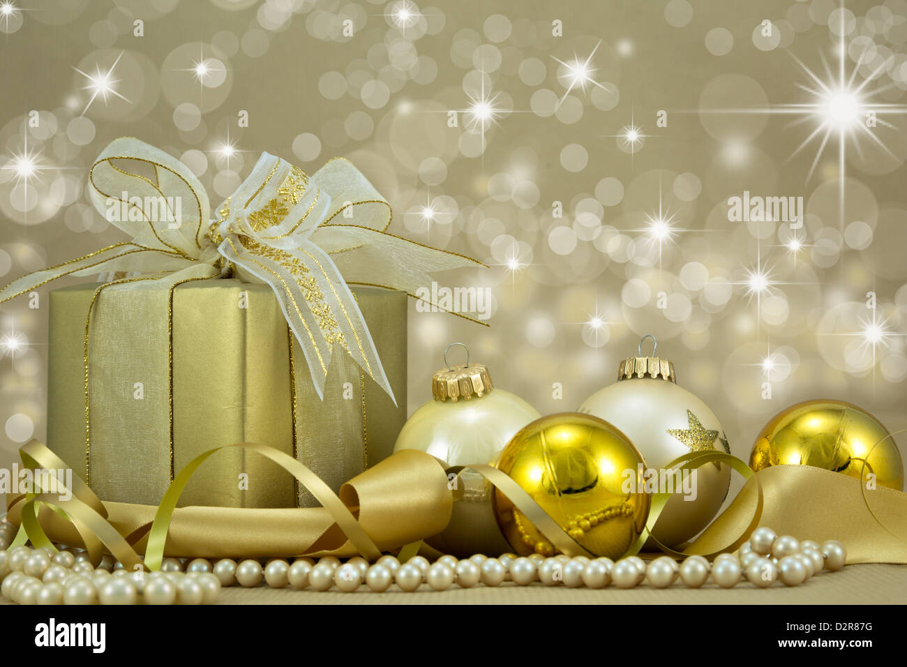 Gold wrapped gift with baubles,ribbon,pearls and diffused sparkle ...