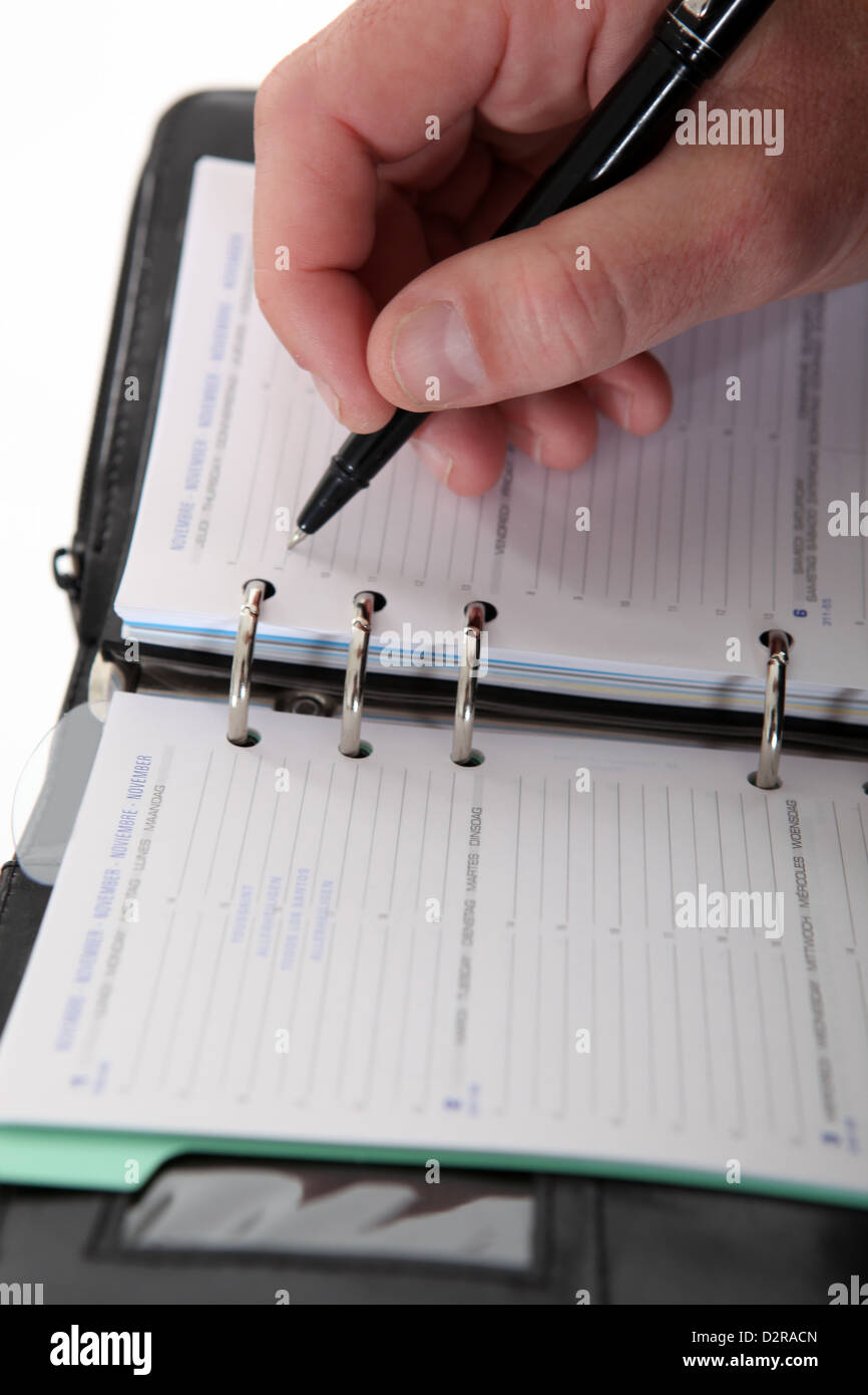 Business people writing in a diary Stock Photo - Alamy