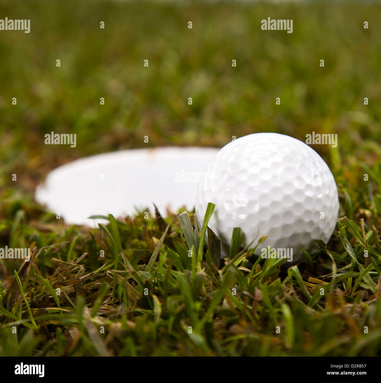 Golf ball on lip of cup Stock Photo - Alamy