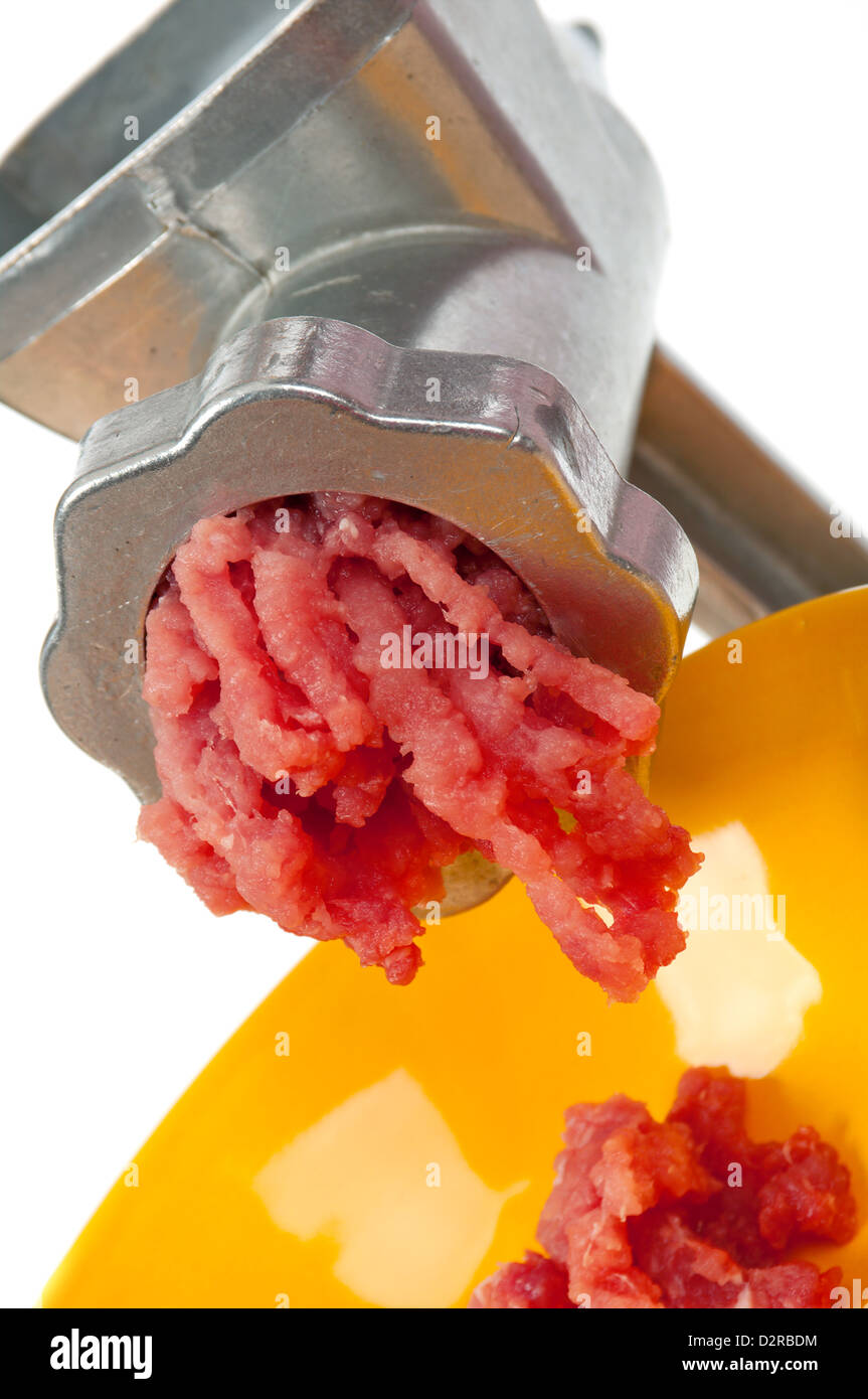 Meat grinder in action. Raw beef Studio, white background Stock Photo ...