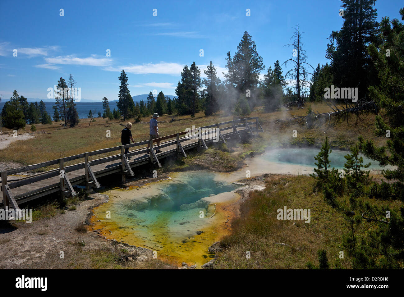 Tourists looking at Seismograph and Bluebell pools, West Thumb Geyser ...