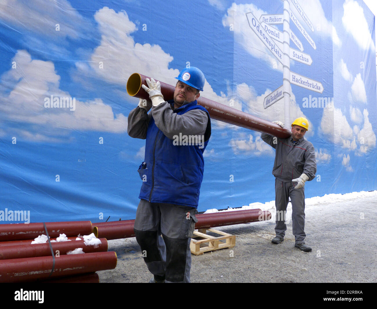 Construction workers carrying metal pipe Stock Photo - Alamy