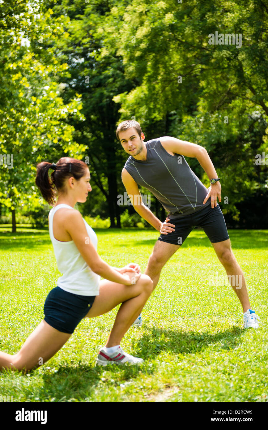 Young couple exercising and stretching muscles before sport activity ...