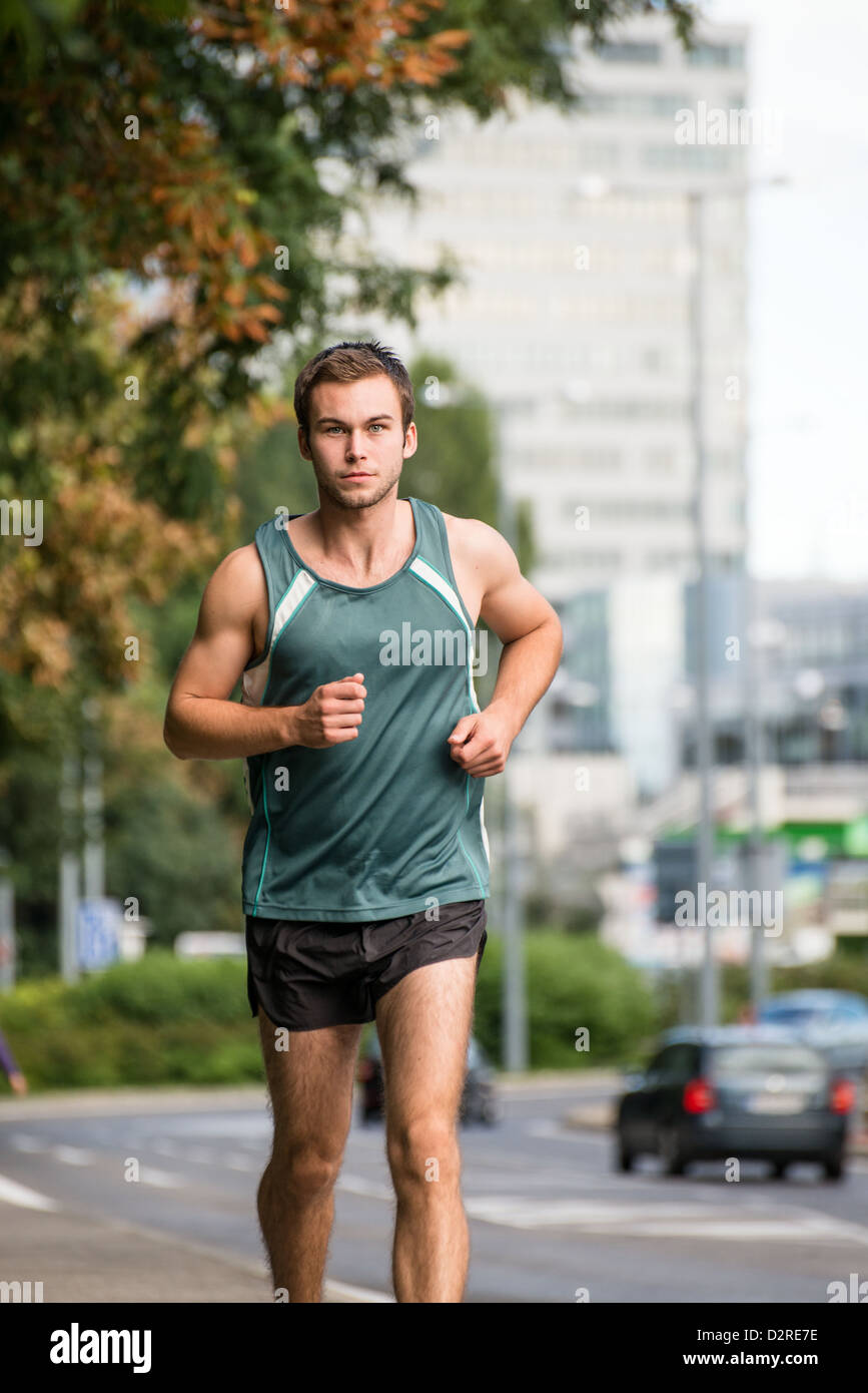Healthy jogging lifestyle - young attractive man running in street ...