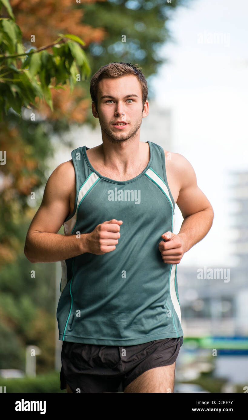 Healthy lifestyle - young attractive man jogging in park Stock Photo ...