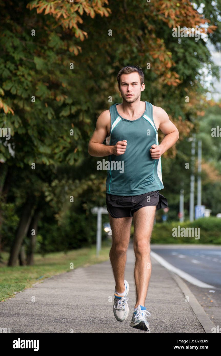 Healthy jogging - young attractive man running in street Stock Photo ...