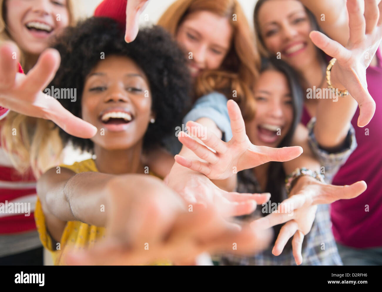 Smiling women reaching forward Stock Photo - Alamy