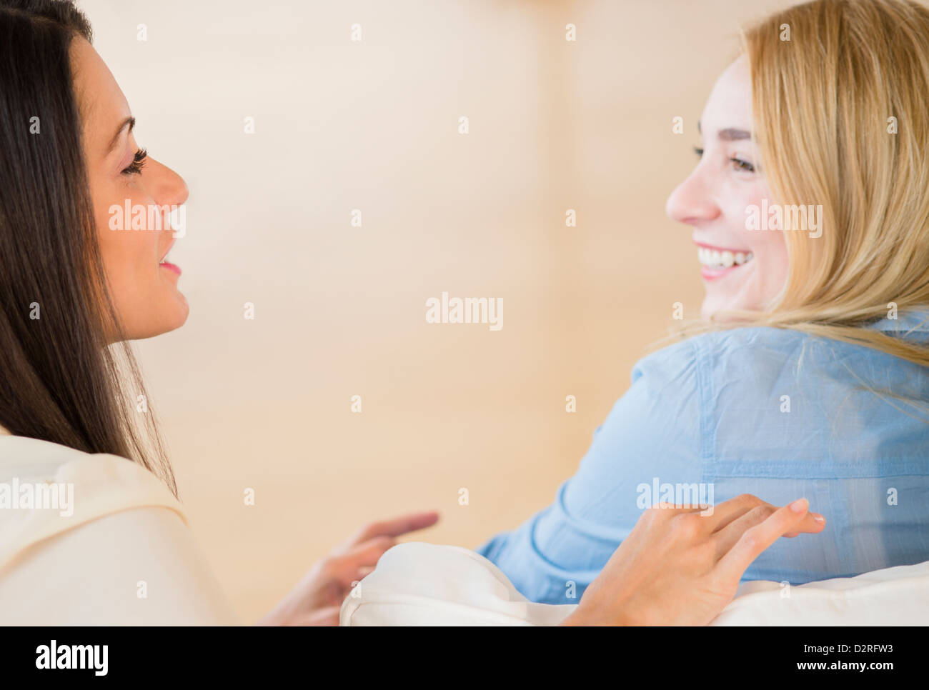 Smiling women talking on sofa Stock Photo - Alamy